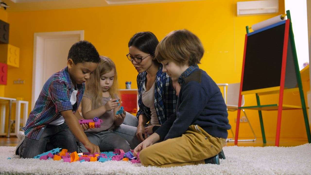 Teacher with little children playing with legos - Free Stock Video