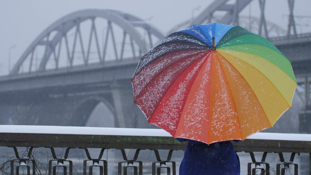 Person with a colorful umbrella on a snowy day - Free Stock Video