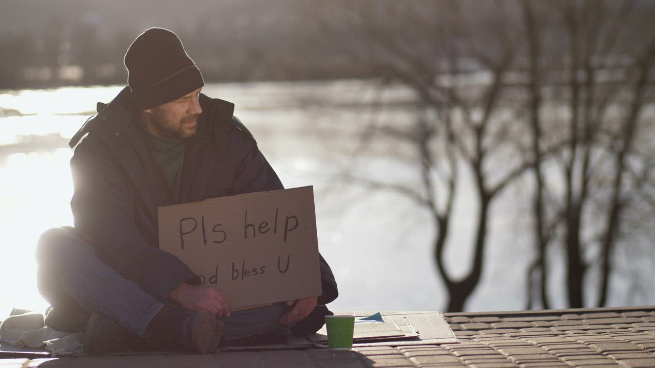 Homeless man on the street with a cardboard sign - Free Stock Video