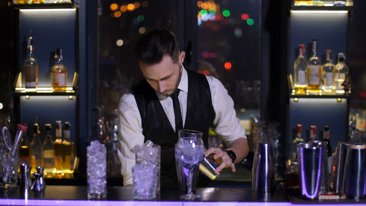 Bar tender juggling ice cubes on a bar - Free Stock Video