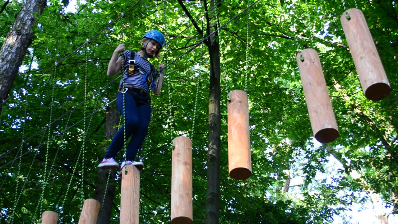 Woman crossing an obstacle bridge in nature - Free Stock Video