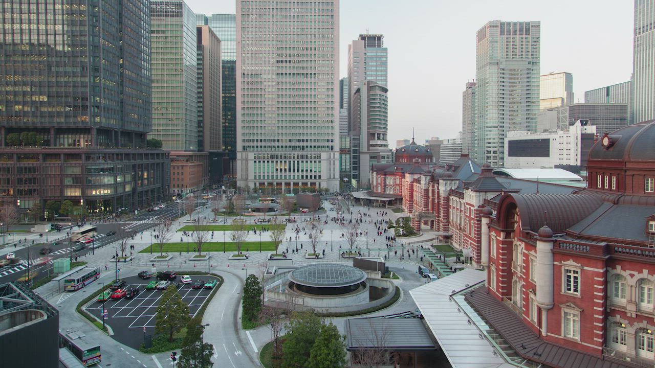 People and cars moving in a city of large buildings - Free Stock Video