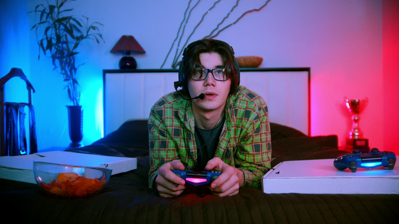 Man in bed playing video games online - Free Stock Video