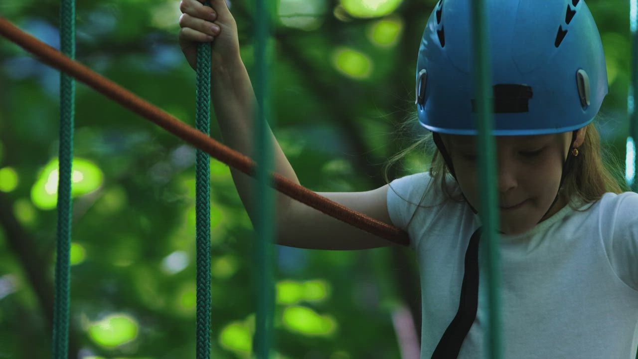 Girl in an a rope adventure in a park - Free Stock Video