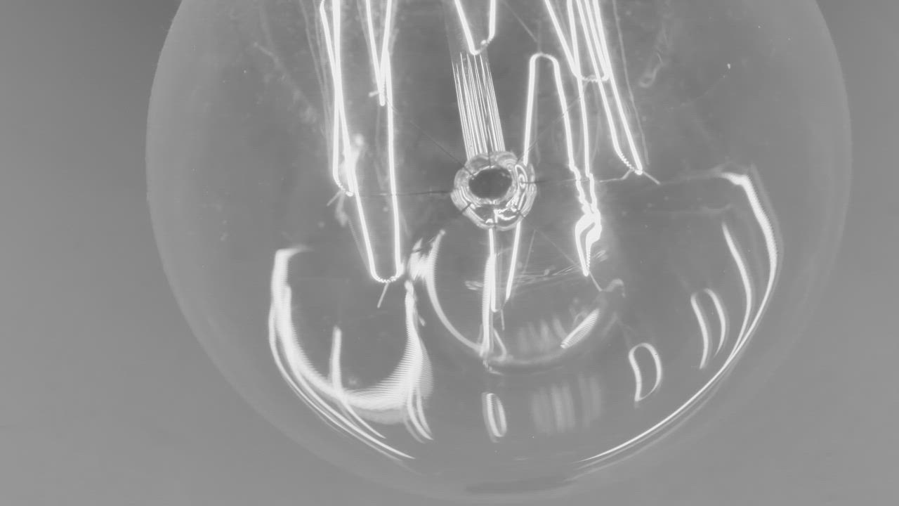 Lit filament reflected in a light bulb - Free Stock Video