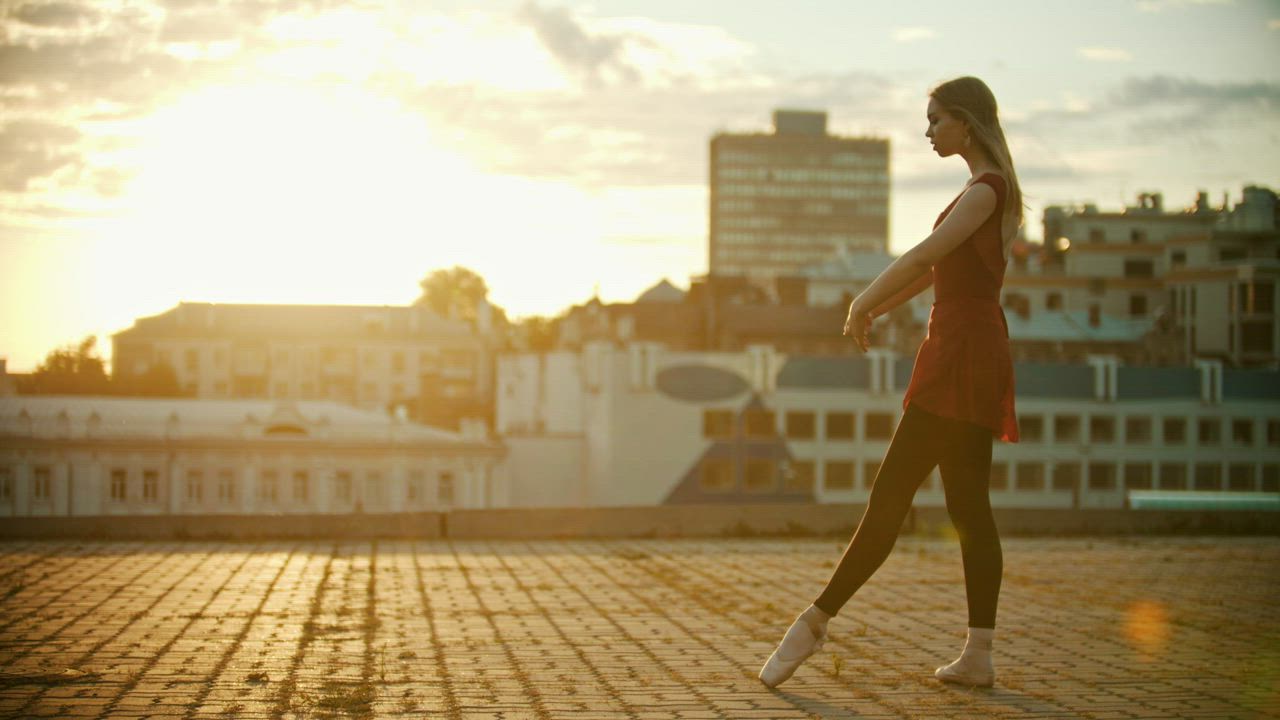 Female ballet dancer taking a leap at sunset - Free Stock Video