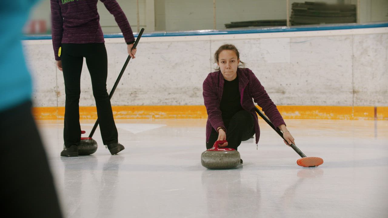 Girl sliding on ice playing curling - Free Stock Video