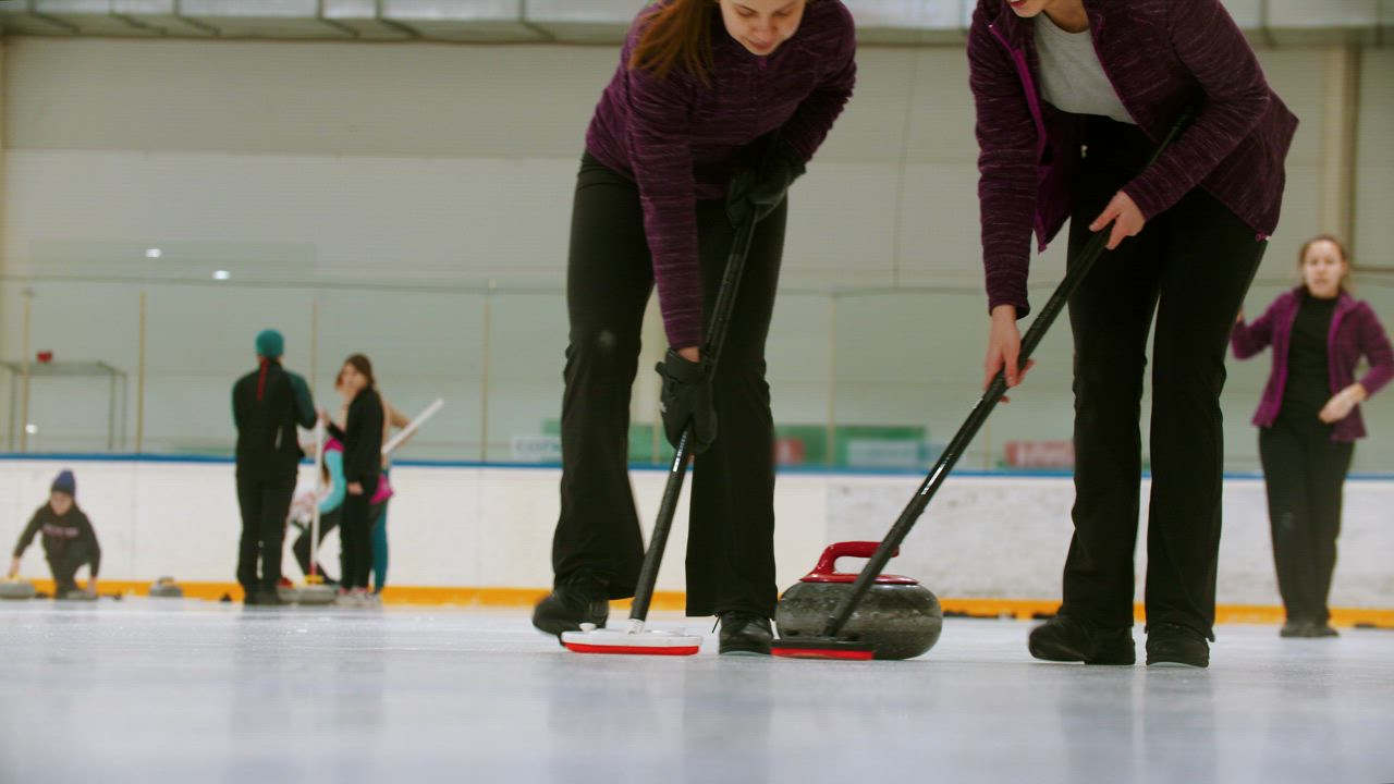 Female curling players in a shot close to the ice - Free Stock Video