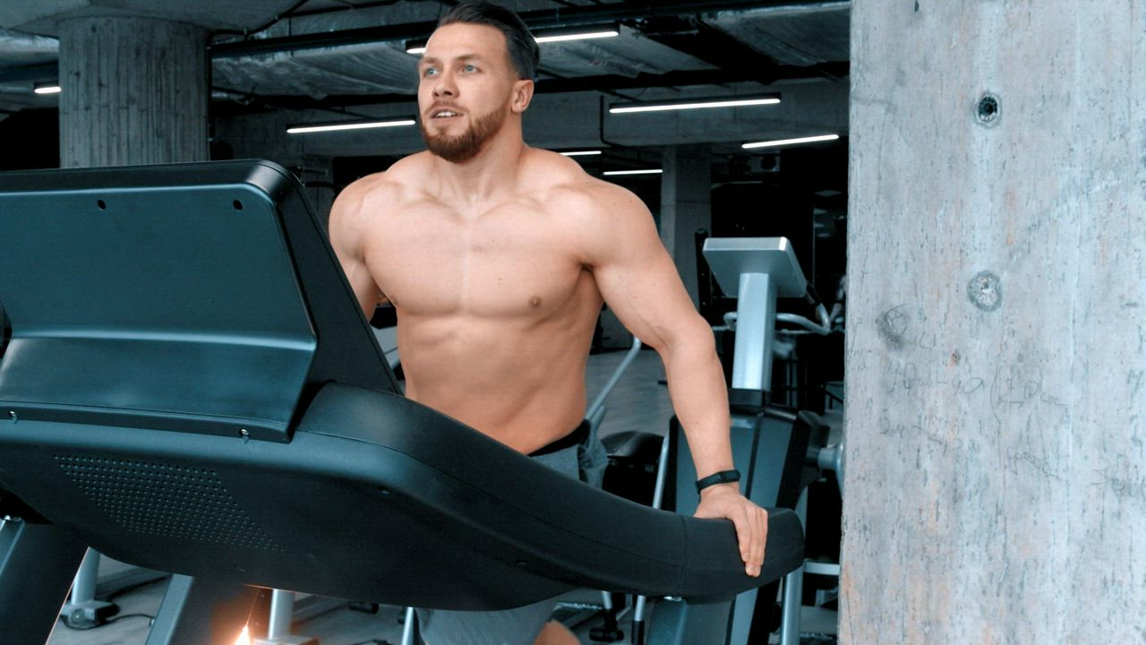 Shirtless bodybuilder running on a treadmill - Free Stock Video