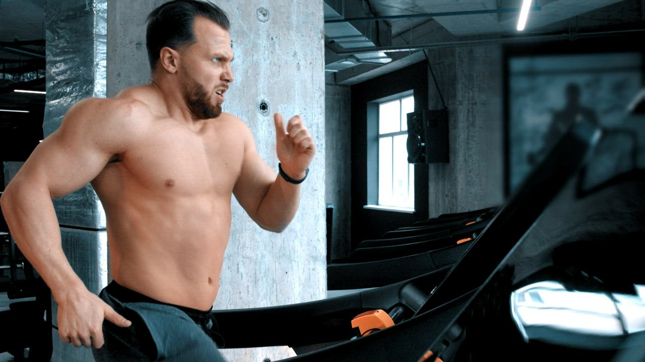 Bodybuilder running on a treadmill - Free Stock Video