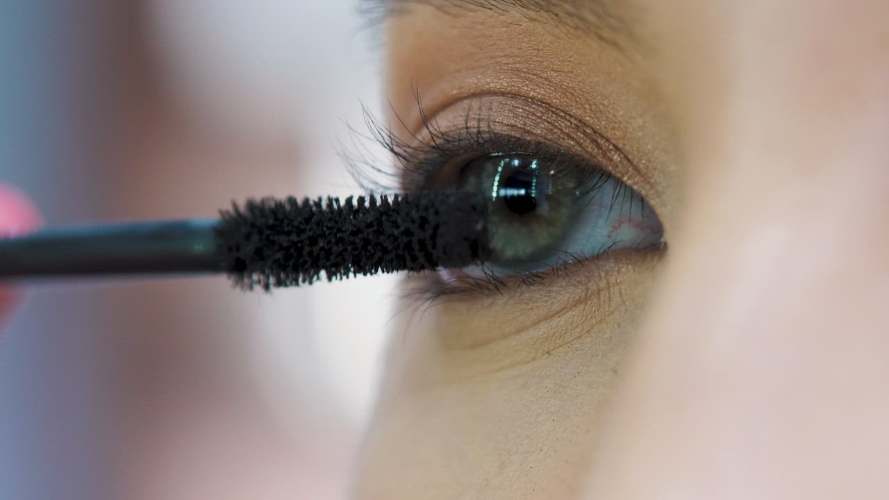 Woman applying mascara in her eyes - Free Stock Video