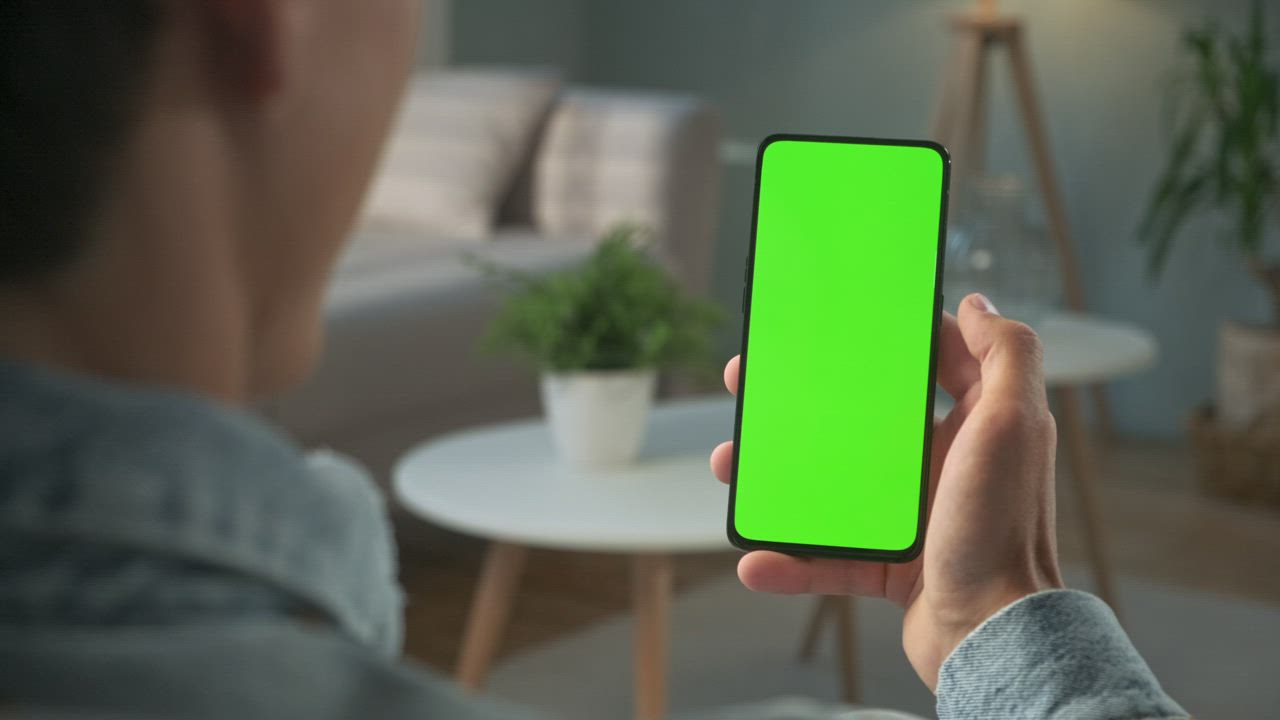 Man watching to a green screen smartphone - Free Stock Video