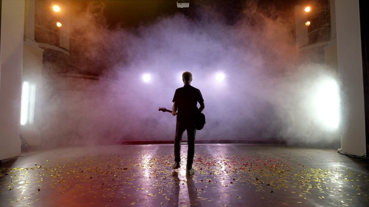 Back view of a guitarist on a stage - Free Stock Video