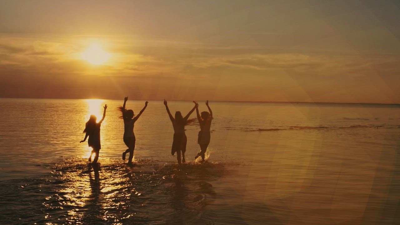 Teenager friends running in the seashore at sunset - Free Stock Video