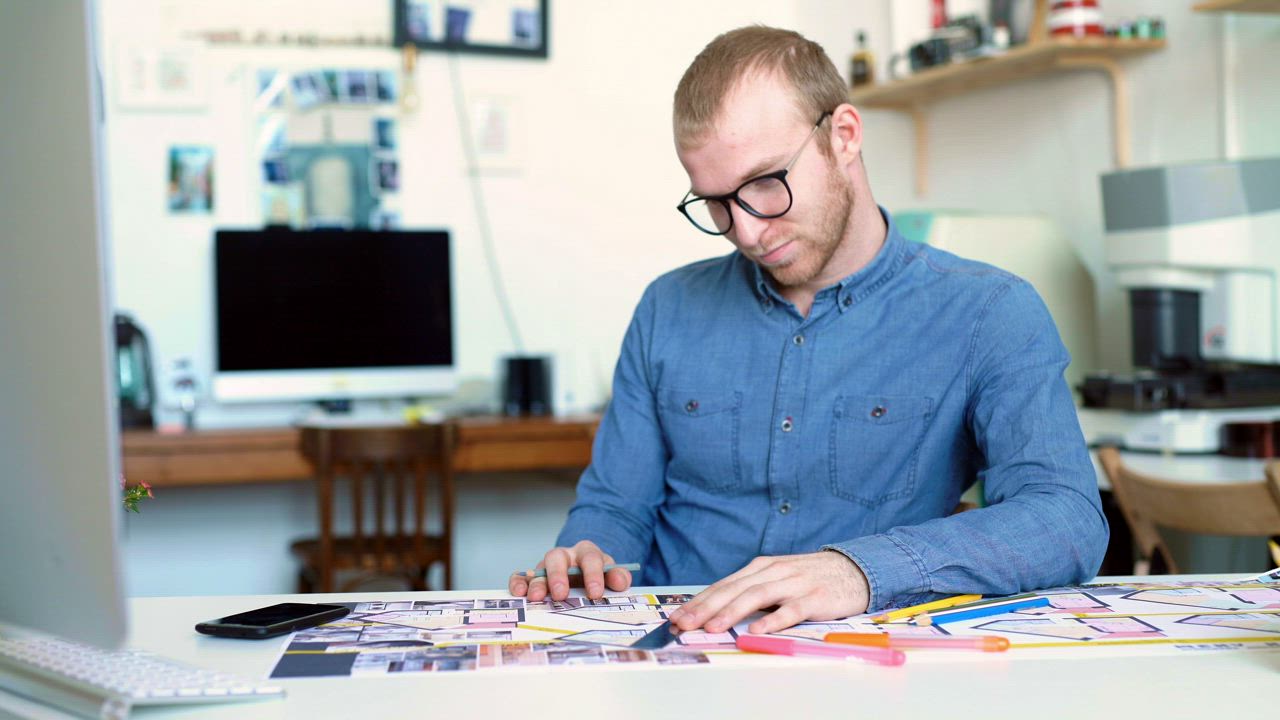 Young architect works concentrated on a blueprint - Free Stock Video