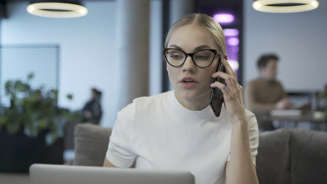 Young woman with glasses talking on the phone - Free Stock Video
