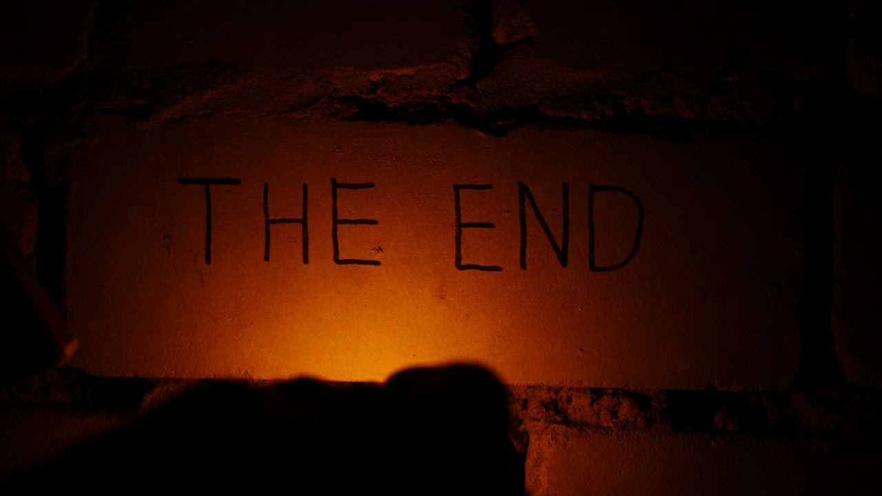 "The end" written on the wall lit with a match - Free Stock Video