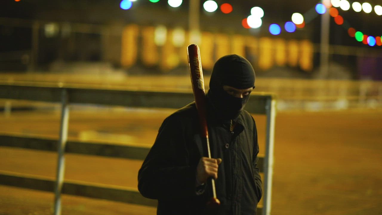 Thug with balaclava walking with a bat - Free Stock Video