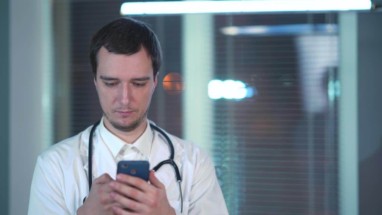 Doctor answering a phone call - Free Stock Video