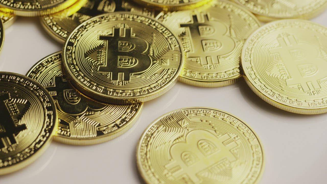 Golden physical bitcoins rotating on a surface - Free Stock Video
