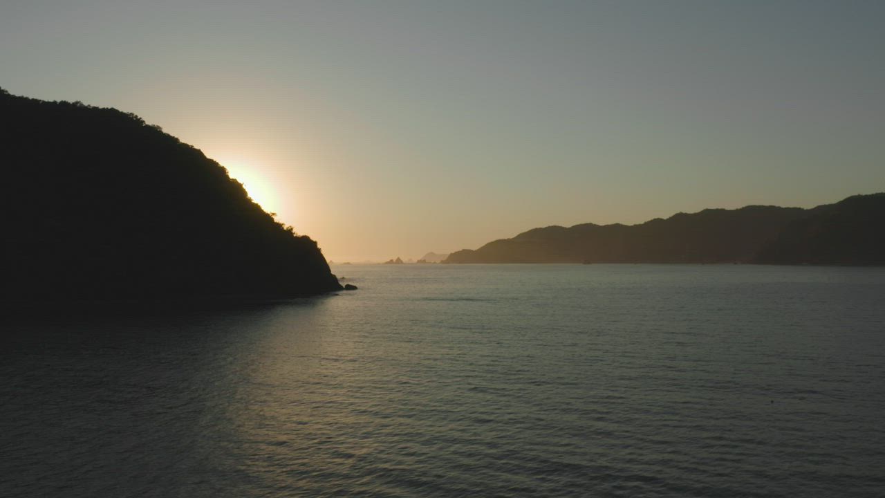 Sunset seen at sea from a coast, aerial shot - Free Stock Video