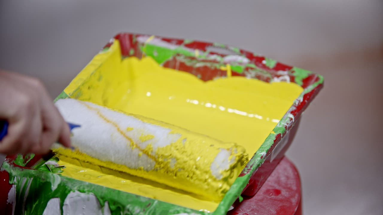 Covering a yellow paint roller - Free Stock Video