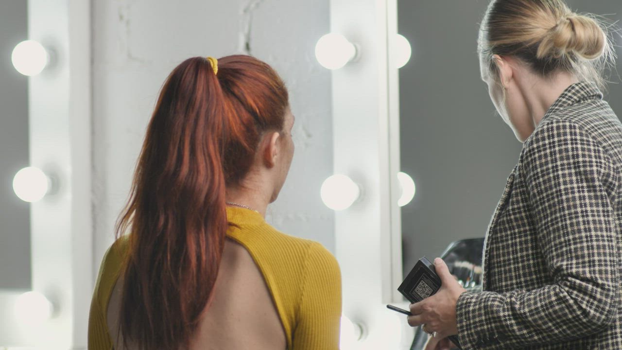 Makeup artist putting makeup on a model in front of a mirror - Free ...