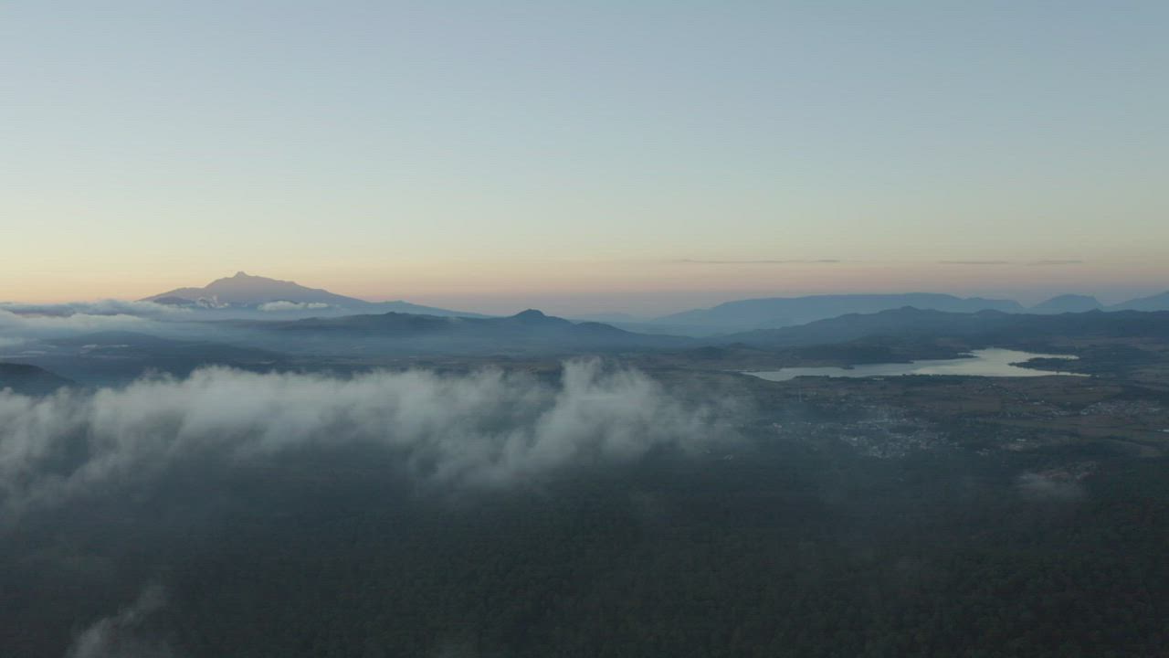 Flying over a landscape with mountains during sunset - Free Stock Video