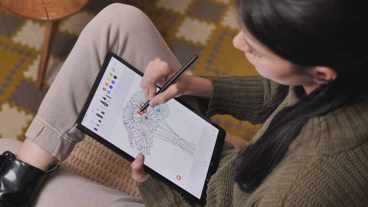 Girl on a sofa coloring flowers on a tablet - Free Stock Video