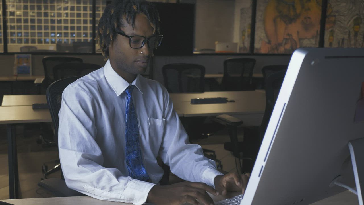 Man working on computer in an office at night - Free Stock Video