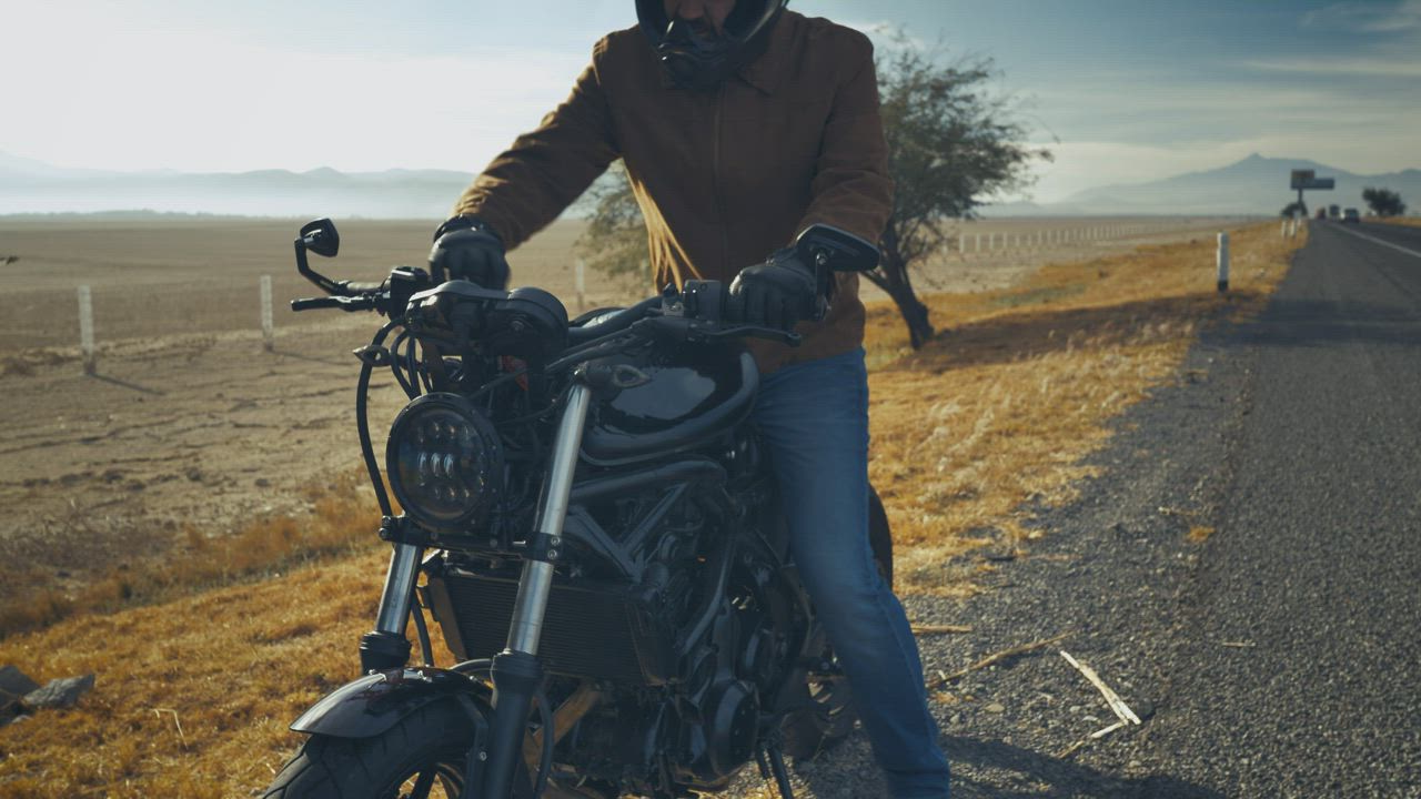 Man riding his motorcycle on the side of a road - Free Stock Video