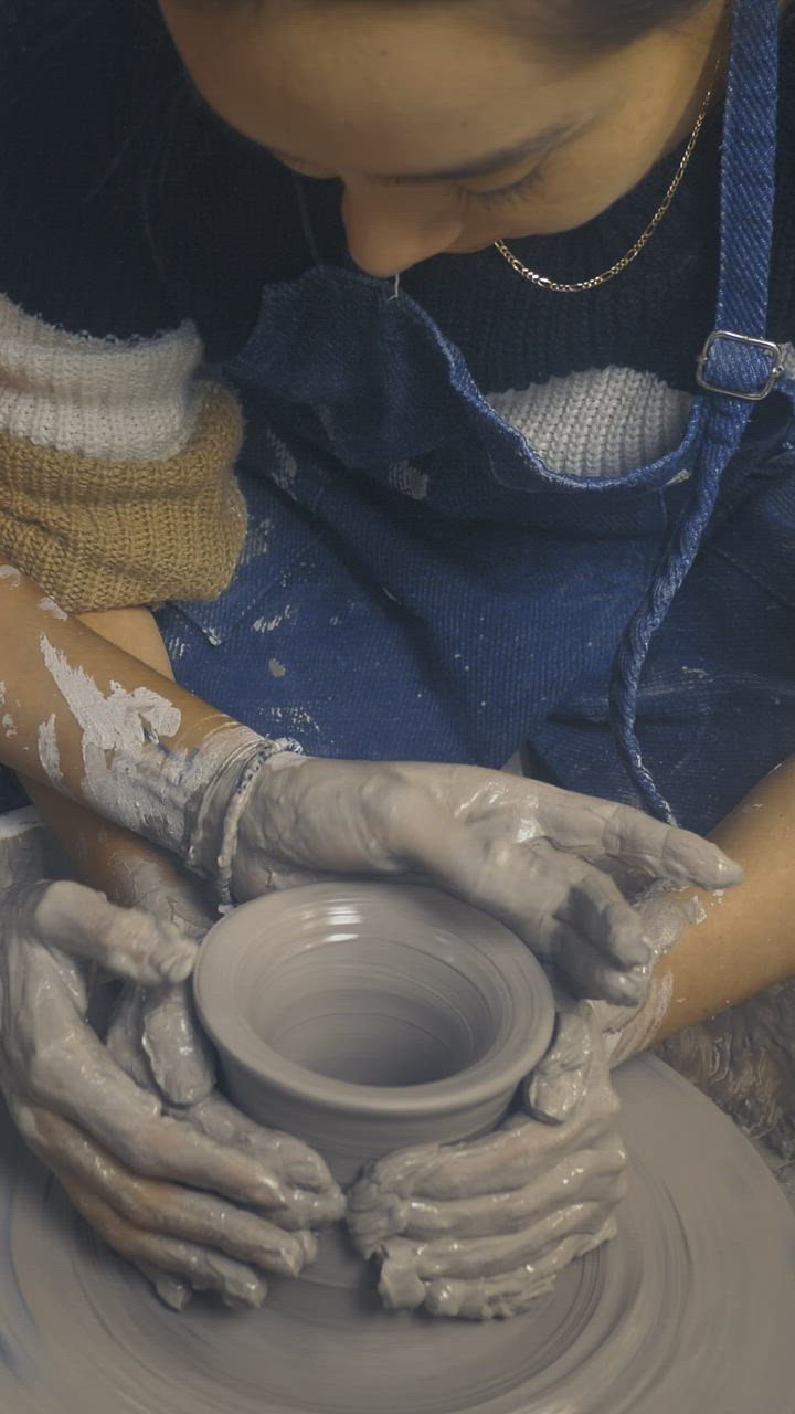 LGBTQ female couple modeling a clay vase together - Free Stock Video