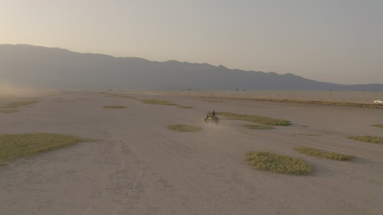 Aerial view of a Jeep traveling through a desert at sunset - Free Stock ...