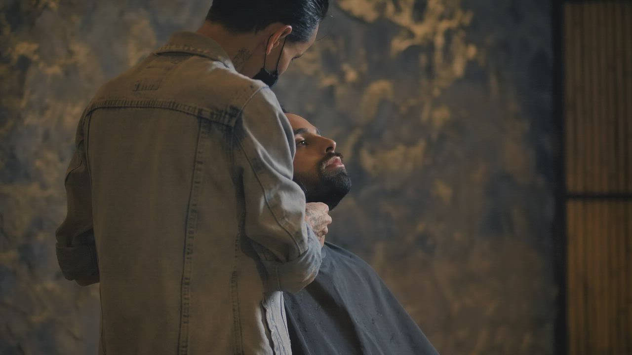 Barber grooming a man's beard - Free Stock Video