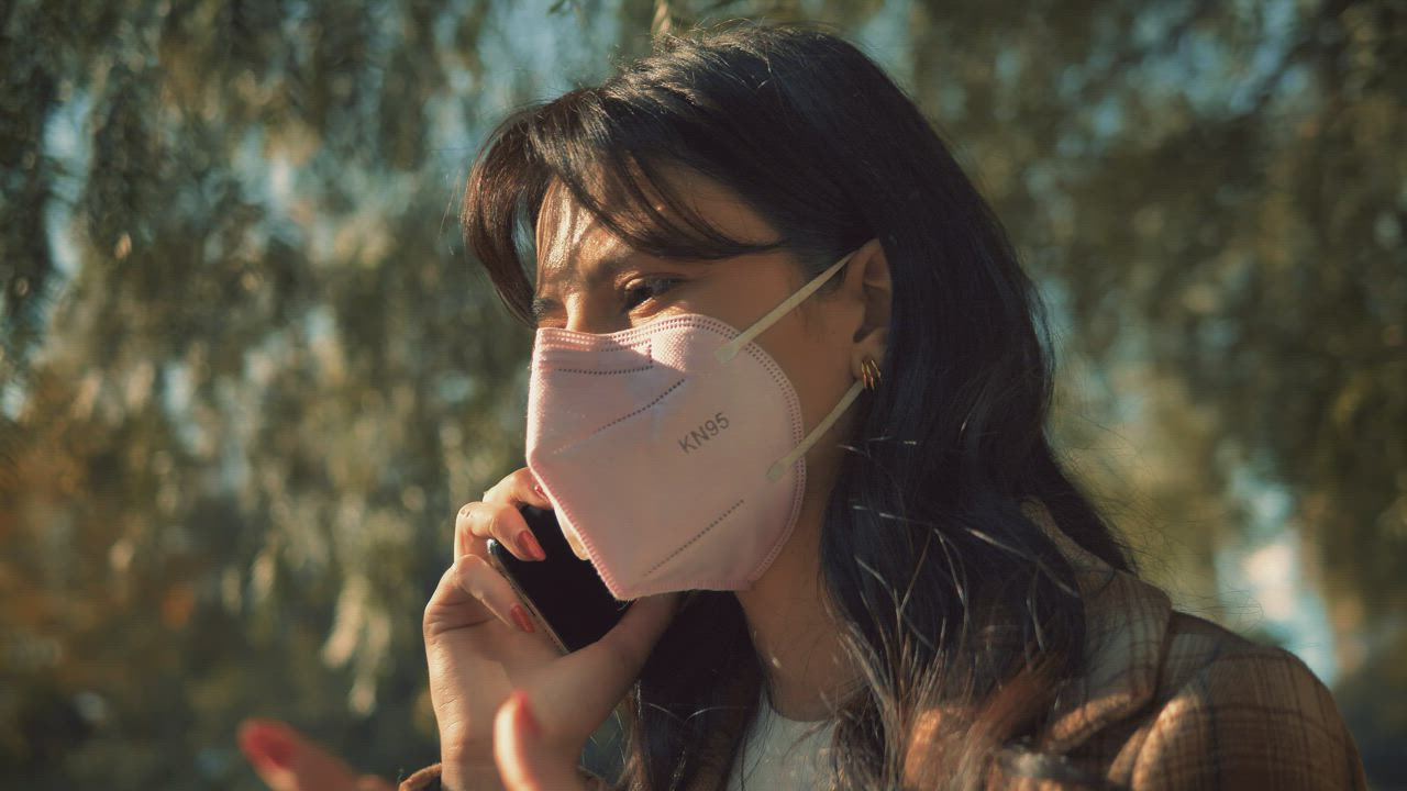 Girl with face mask talking on the cellphone - Free Stock Video
