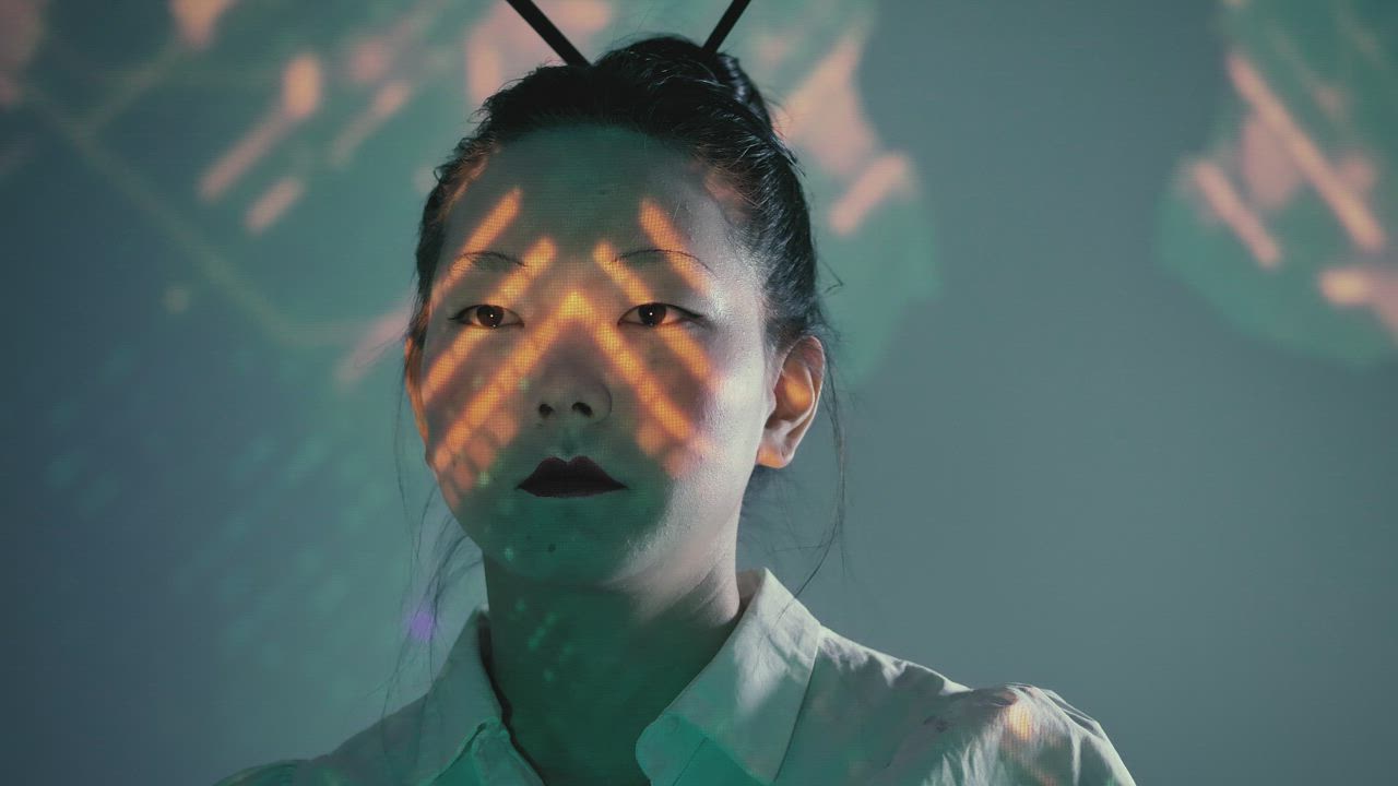 Female cyborg raising hand and looking at the camera - Free Stock Video