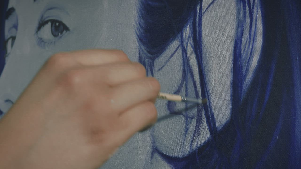Artist's hand painting the hair of a portrait - Free Stock Video