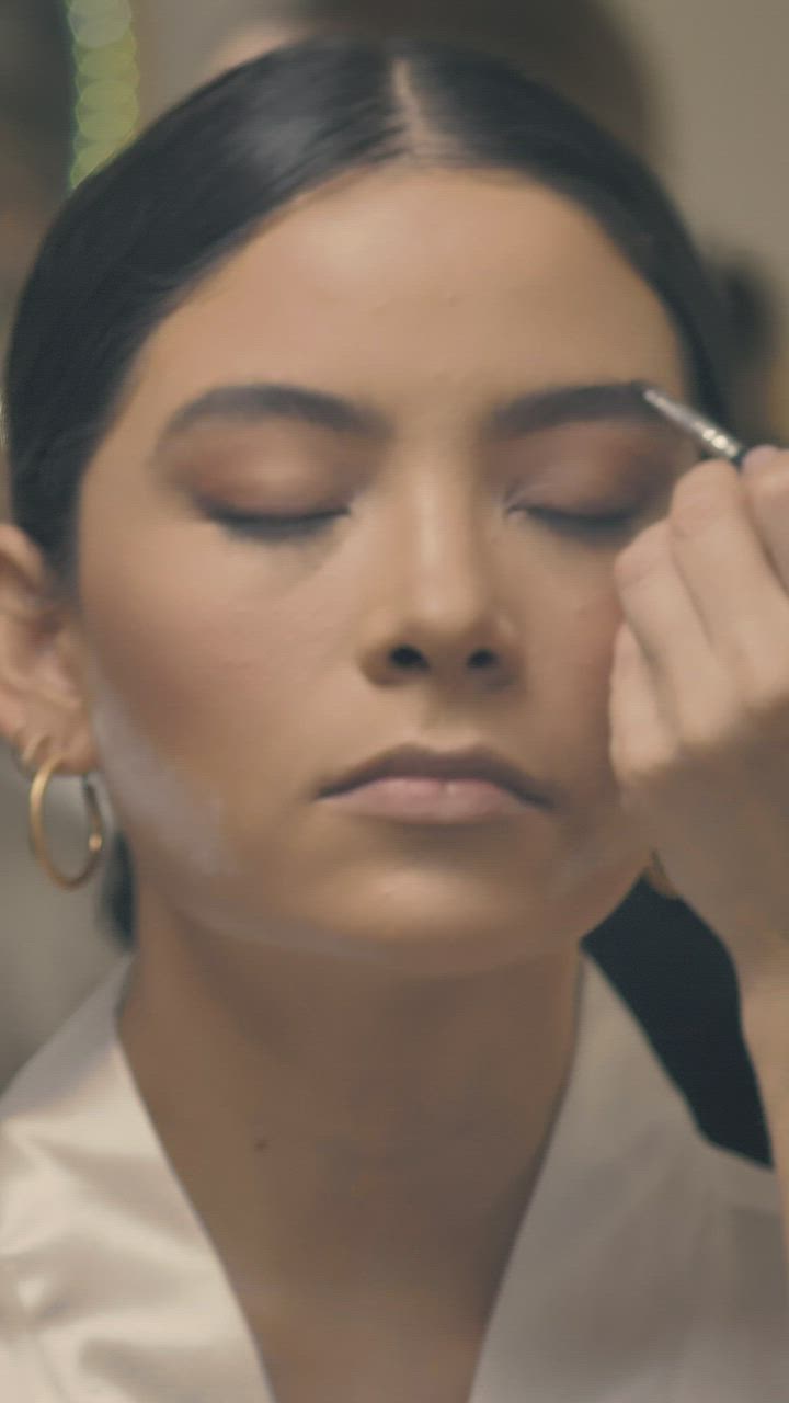 A makeup artist with face mask putting on makeup - Free Stock Video