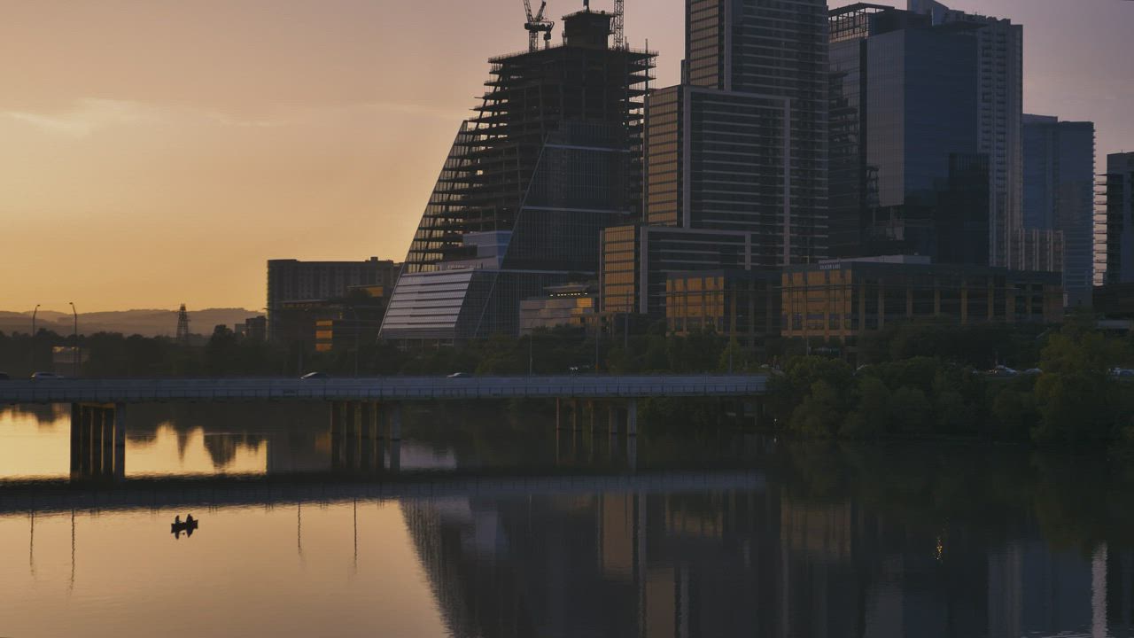 Big city of tall buildings at sunset from a lake - Free Stock Video