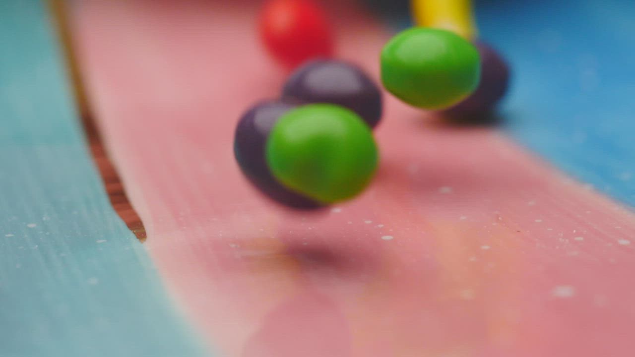 Fruit-shaped sweets slowly falling into a bowl - Free Stock Video
