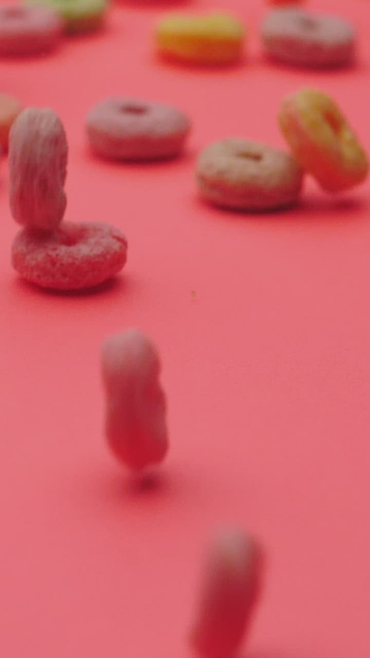 Sugar ring cereal gliding across a pink surface - Free Stock Video