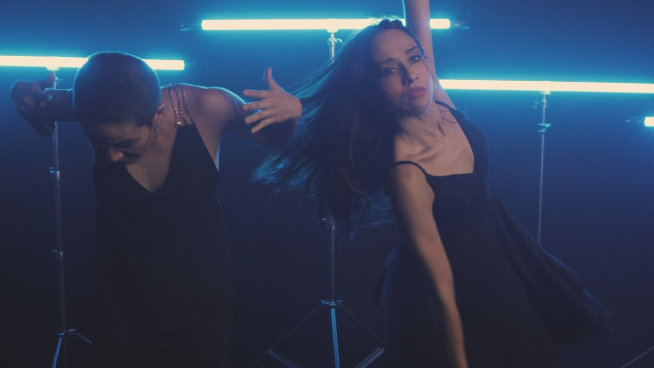 Women dancing energetically with neon blue lights - Free Stock Video