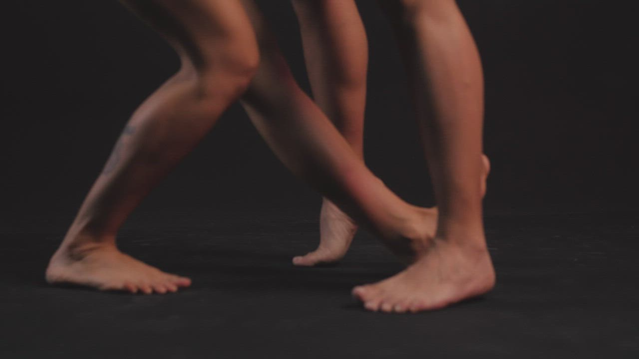 Feet of a pair of women dancing on a dark platform - Free Stock Video