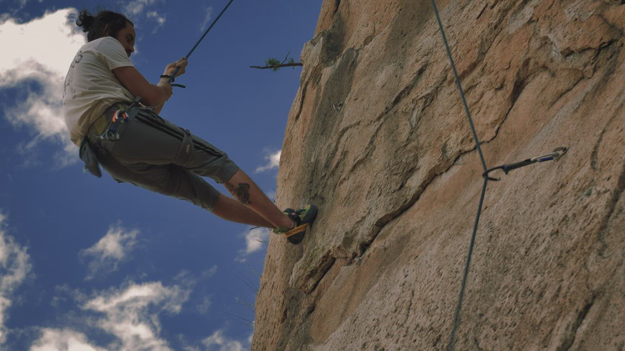 Mountaineer coming down from a mountain with a rope - Free Stock Video