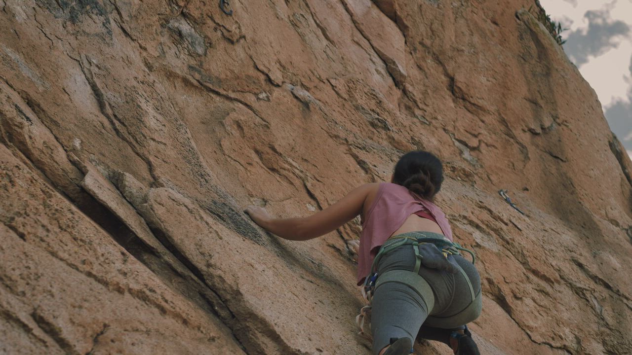 Bottom view of a girl climbing a mountain - Free Stock Video