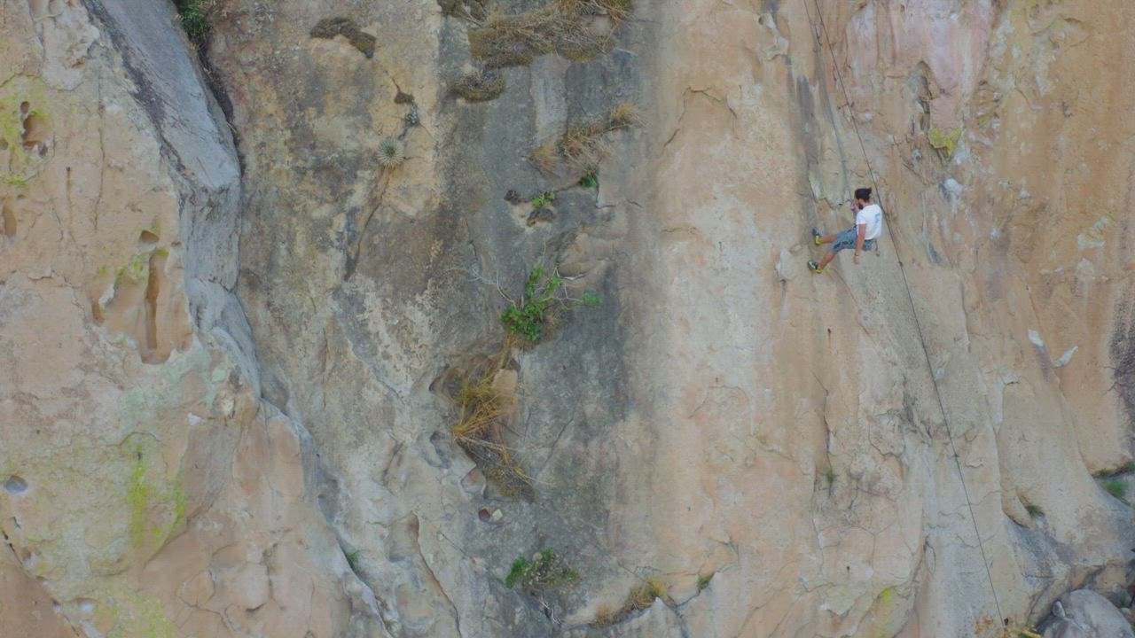 Mountaineer descending from a large mountain with a rope - Free Stock Video