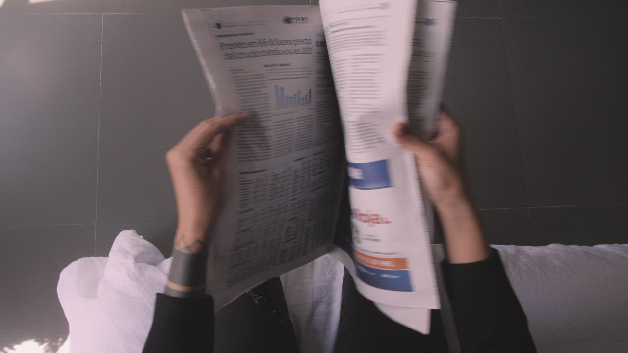 POV flipping through a newspaper - Free Stock Video