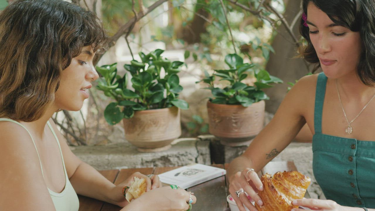 Two friends eating bread during a friends date - Free Stock Video