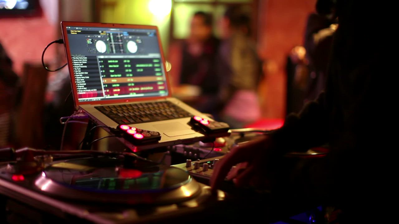 DJ behind the turntables with a computer - Free Stock Video