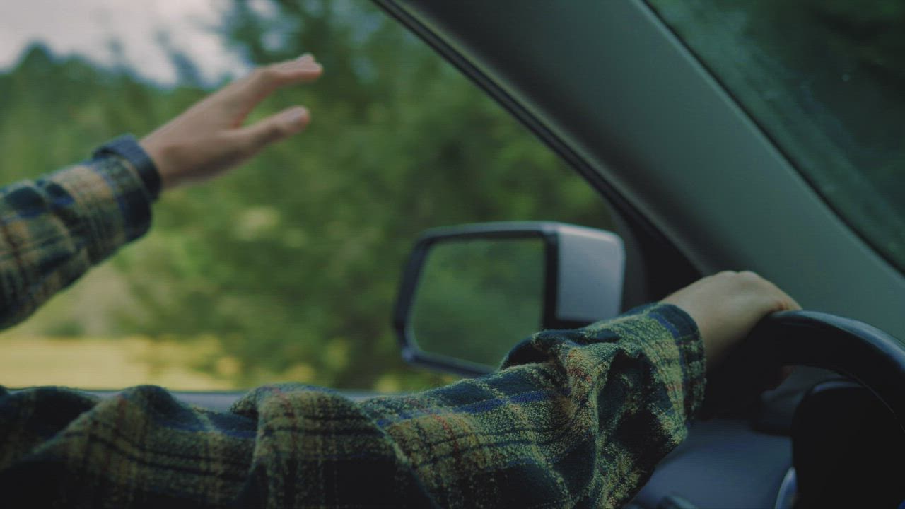 Man driving through nature enjoying the wind - Free Stock Video